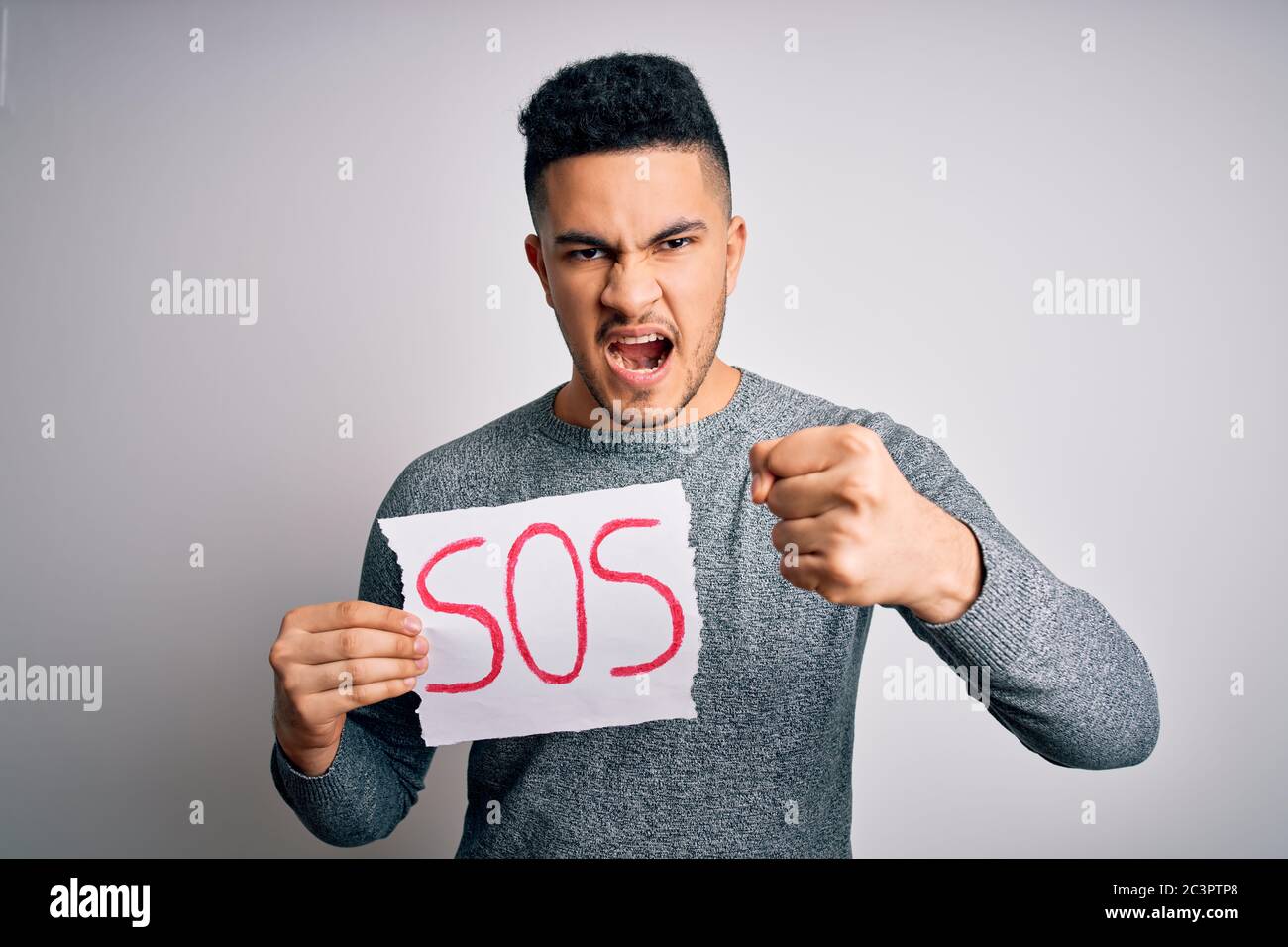Young handsome man with problem holding banner with sos message over ...