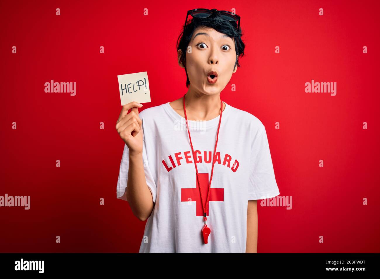 Young beautiful asian lifeguard girl using whistle holding reminder ...
