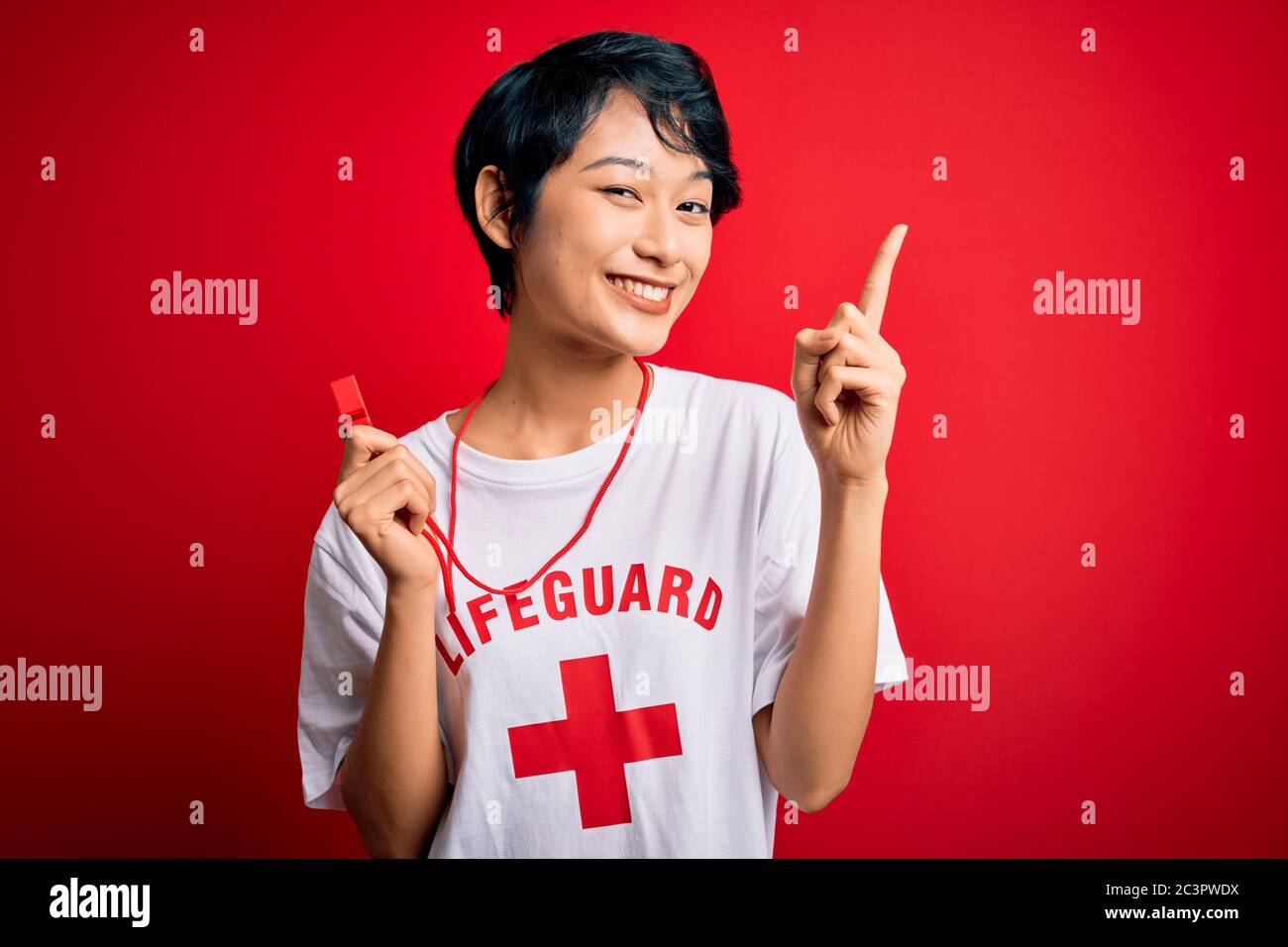 Young beautiful asian lifeguard girl wearing t-shirt with red cross ...