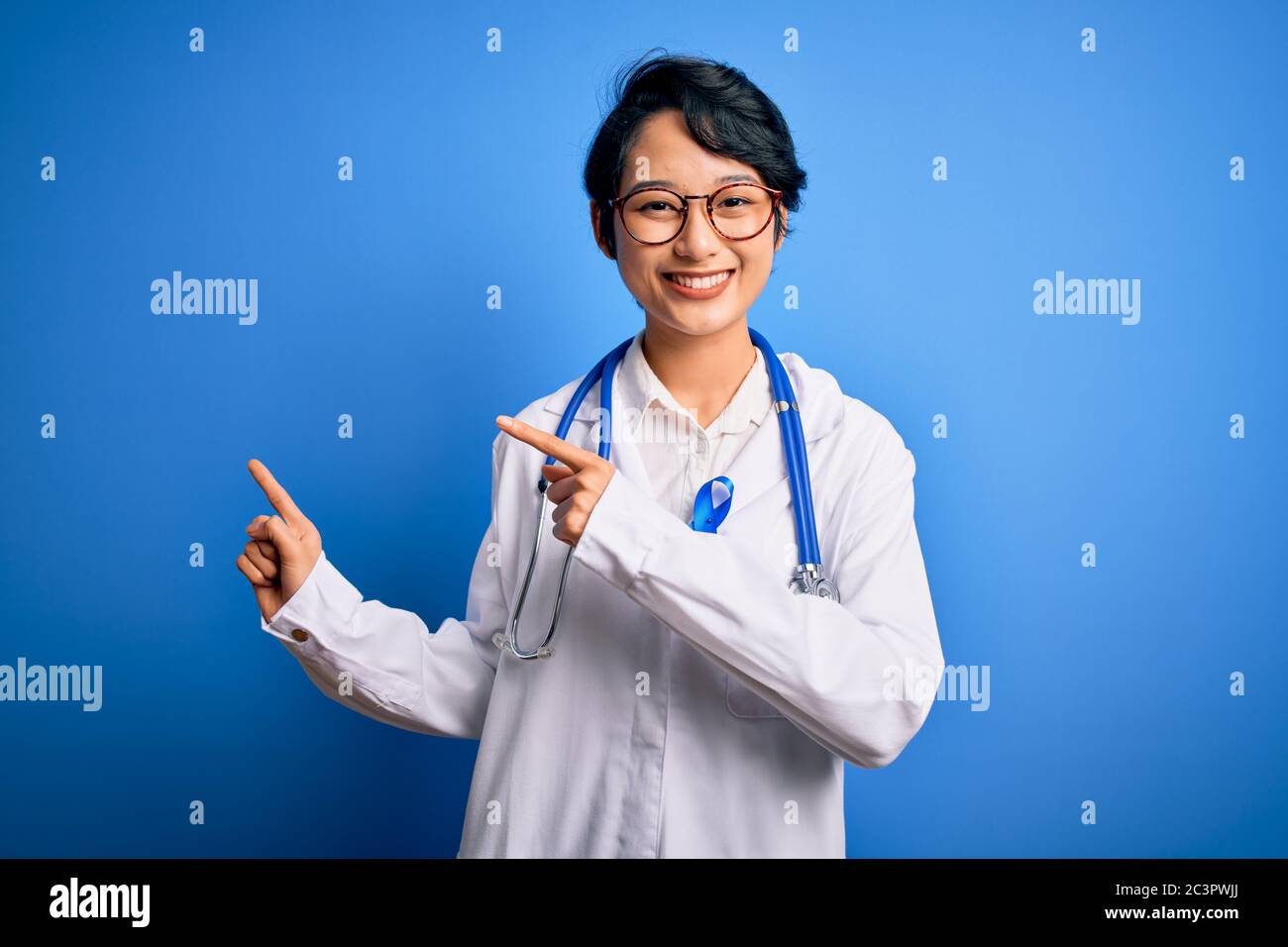 Young beautiful asian doctor girl wearing stethoscope and coat with ...