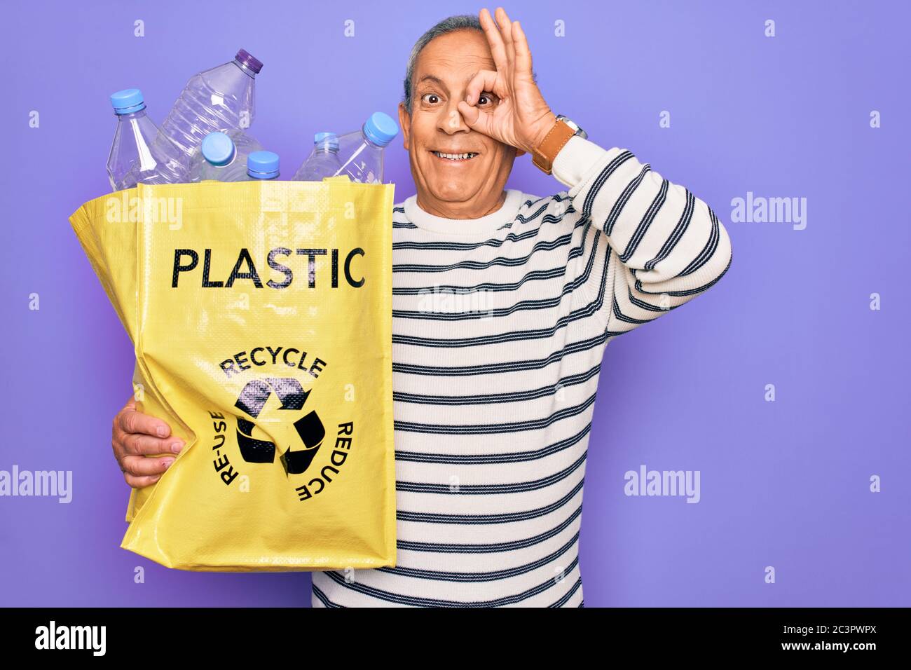 Senior man recycling holding bag with plastic bottles to recycle over ...
