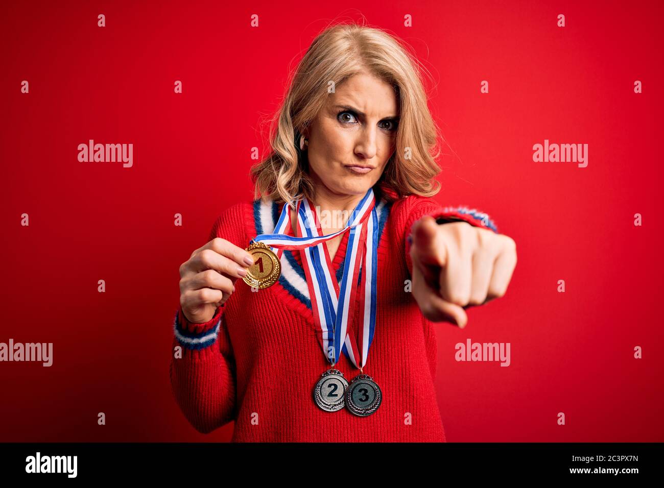 Middle age beautiful blonde successful woman winning medals over red ...