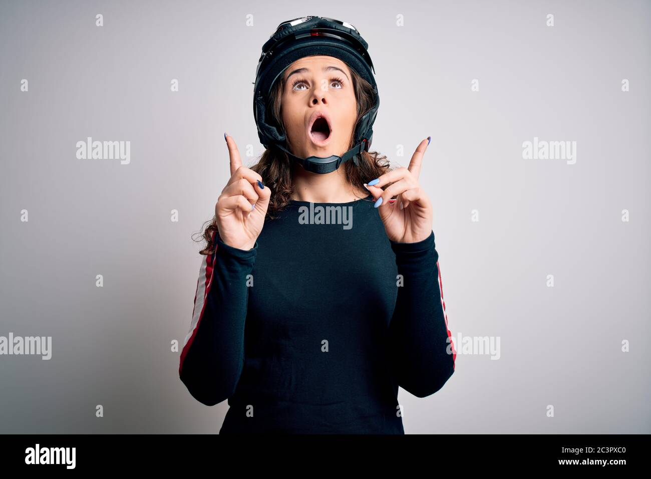 Beautiful motorcyclist woman with curly hair wearing moto helmet over ...