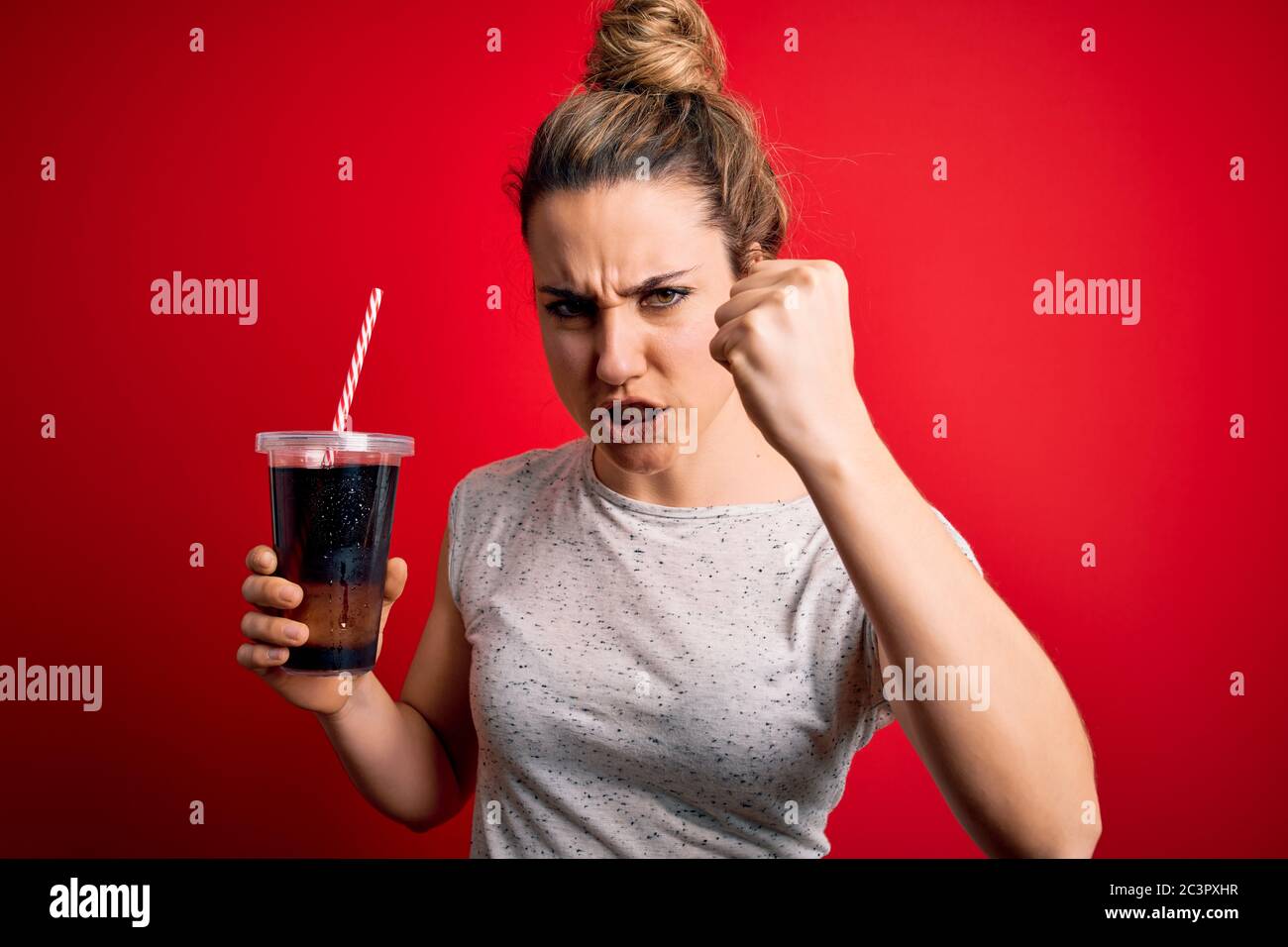 Beautiful blonde woman drinking cola fizzy beverage to refreshment over ...