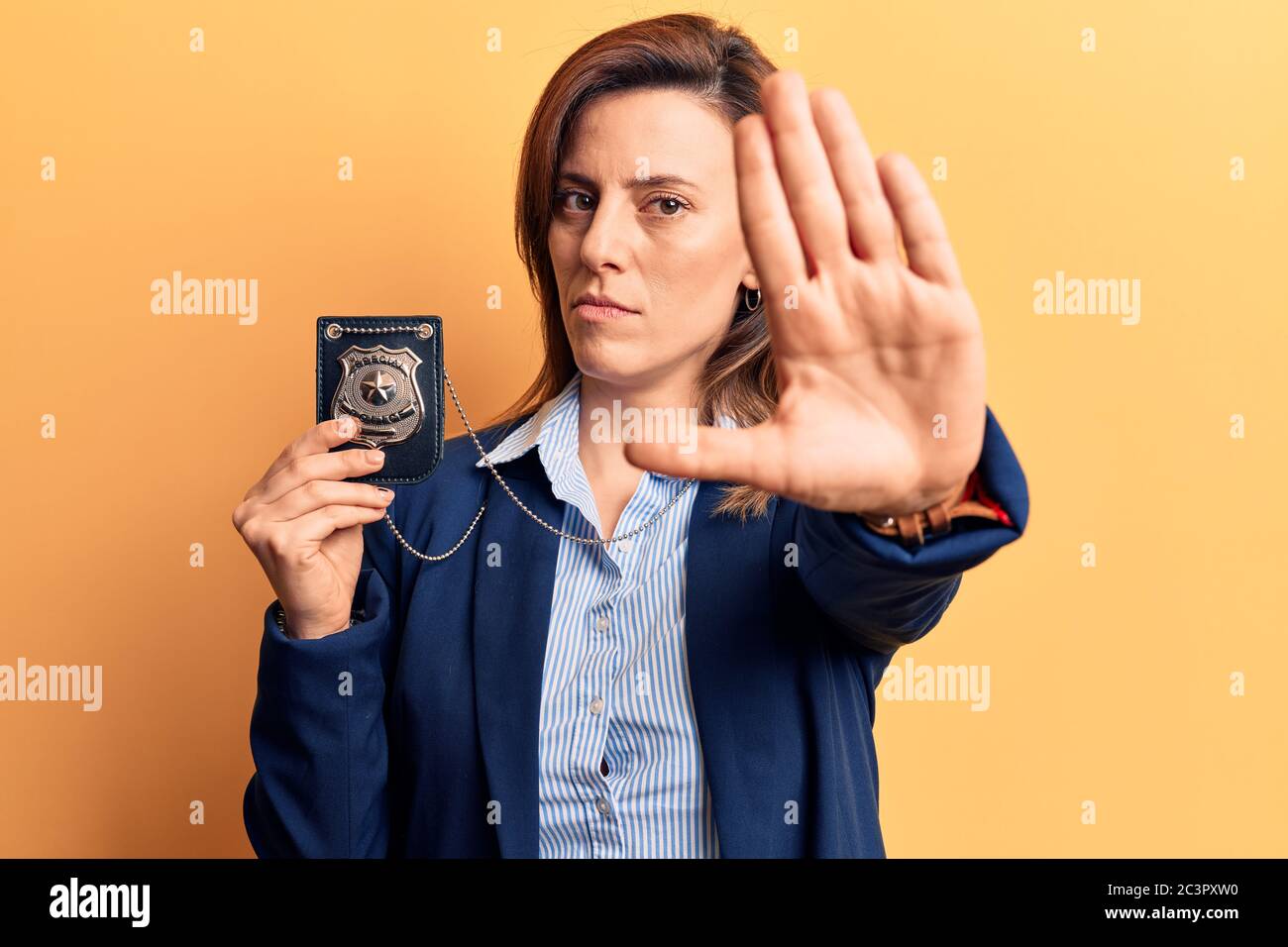 Young beautiful woman holding detective badge with open hand doing stop ...