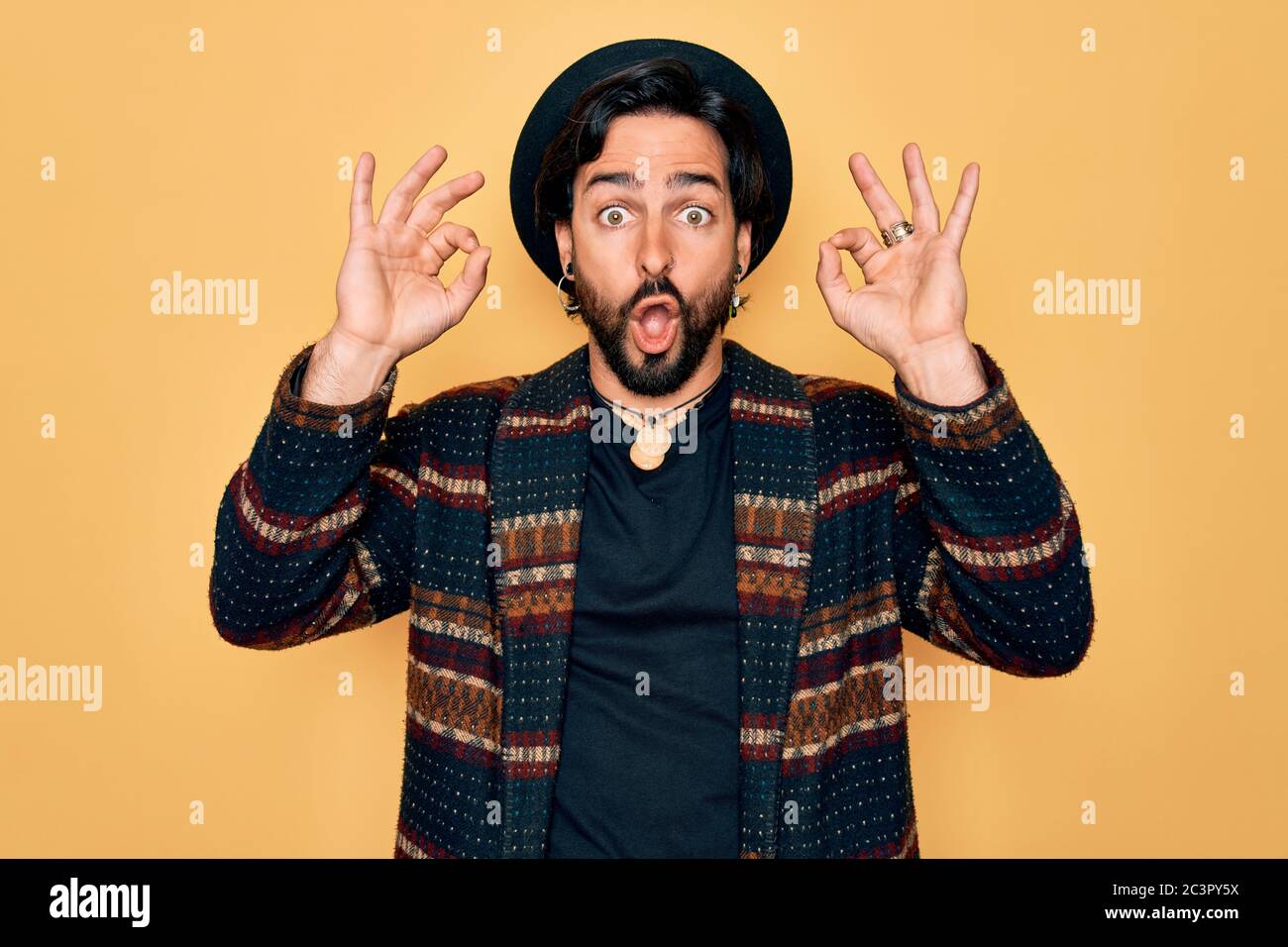 Young handsome hispanic bohemian man wearing hippie style and boho hat ...