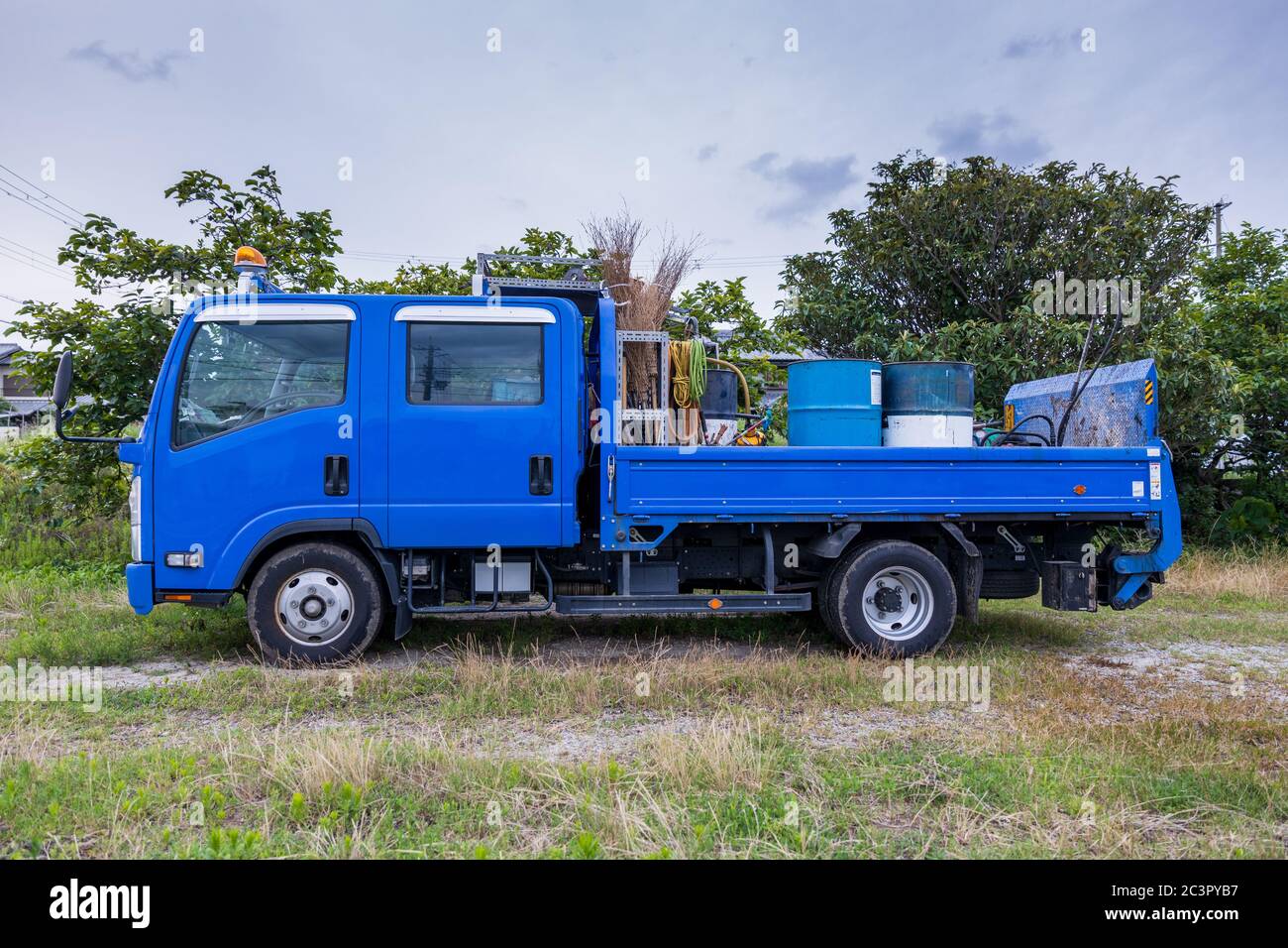 Side view of blue flatbed work truck with equipment in back Stock Photo ...