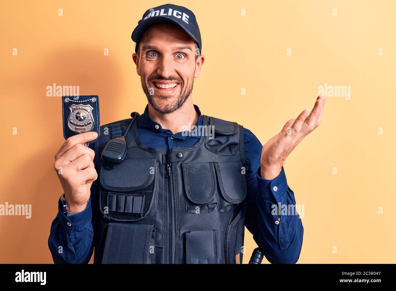 Young handsome policeman wearing uniform and bulletprof holding police ...