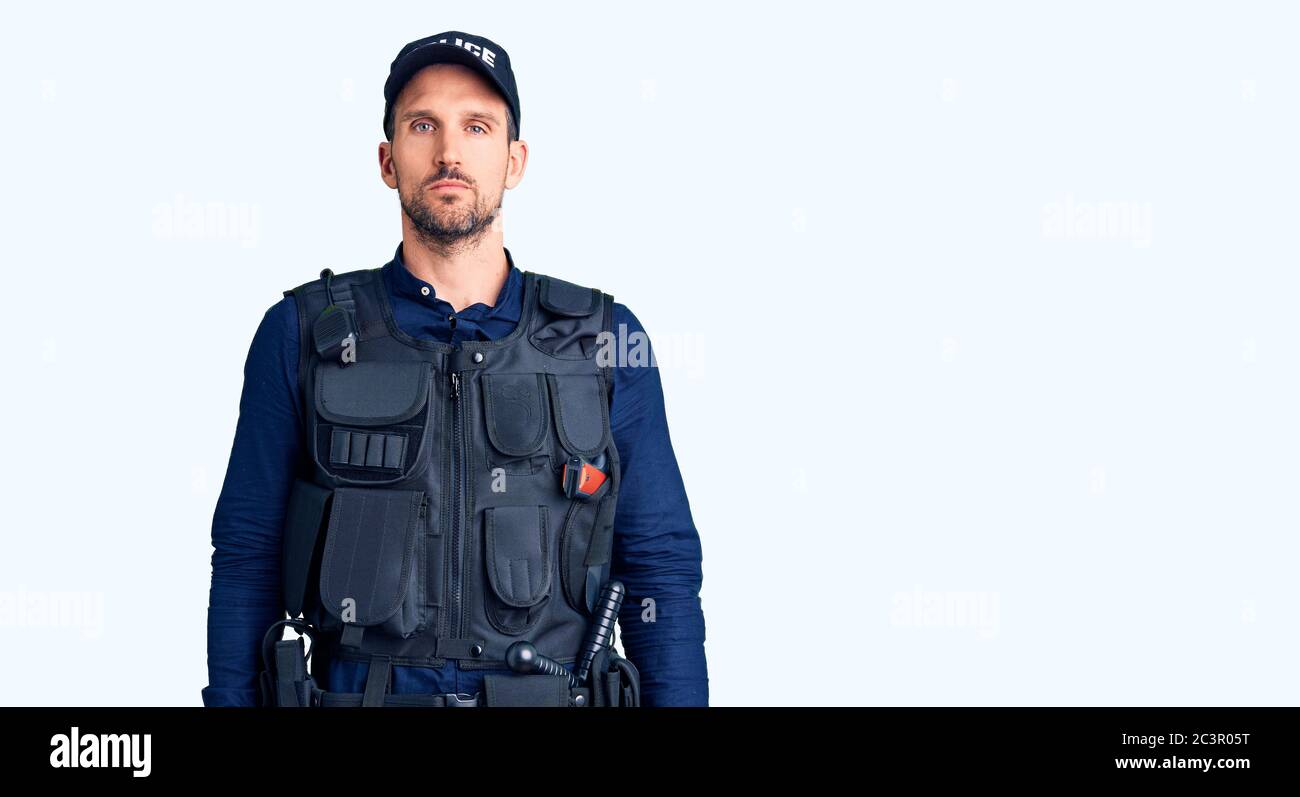 Young handsome man wearing police uniform looking sleepy and tired ...