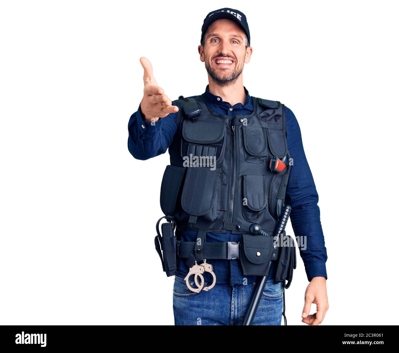 Young handsome man wearing police uniform smiling friendly offering ...