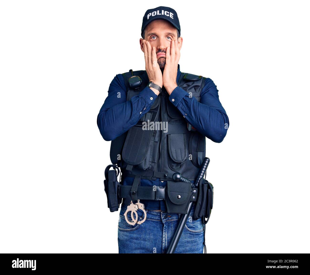 Young handsome man wearing police uniform tired hands covering face ...