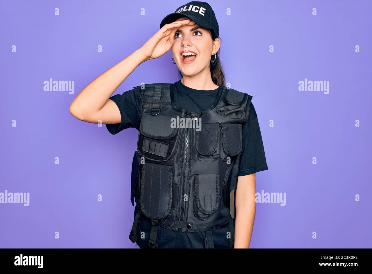 Young police woman wearing security bulletproof vest uniform over ...