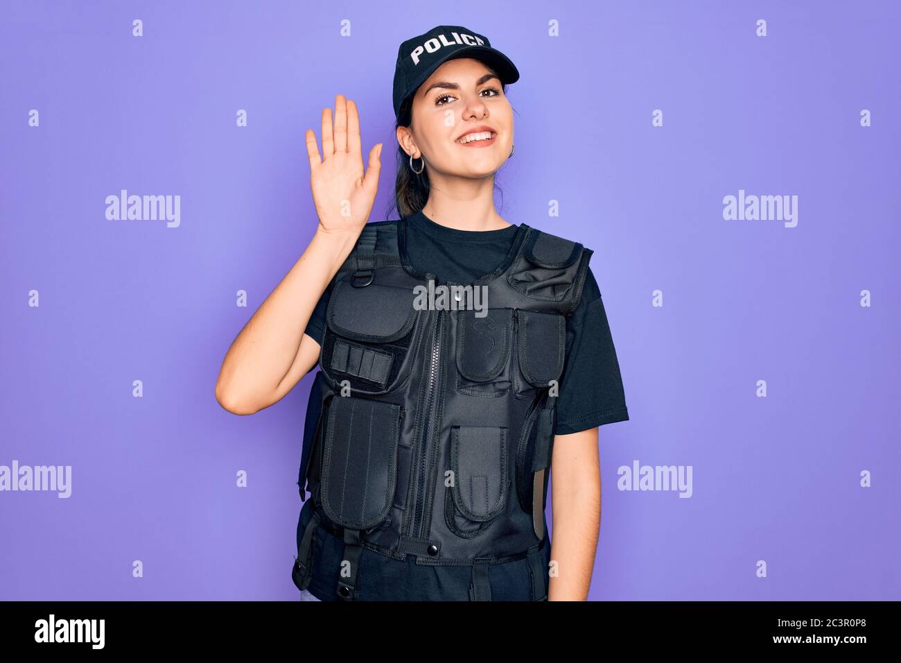 Young police woman wearing security bulletproof vest uniform over ...