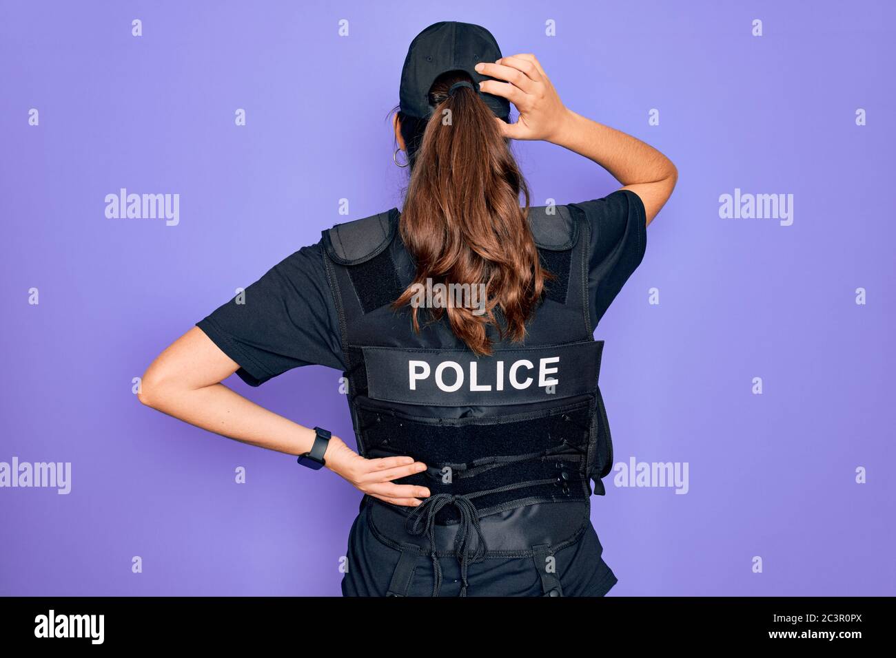 Young police woman wearing security bulletproof vest uniform over ...