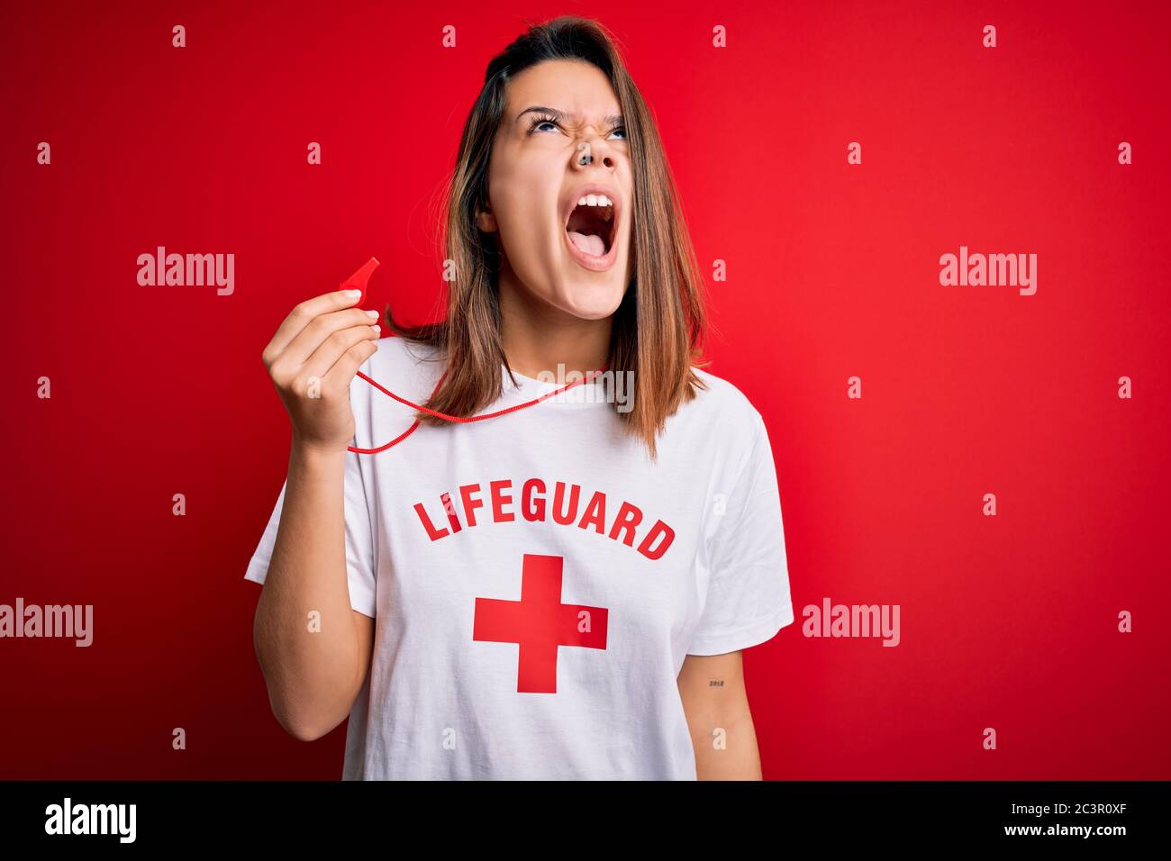 Young beautiful brunette lifeguard girl wearing t-shirt with red cross ...