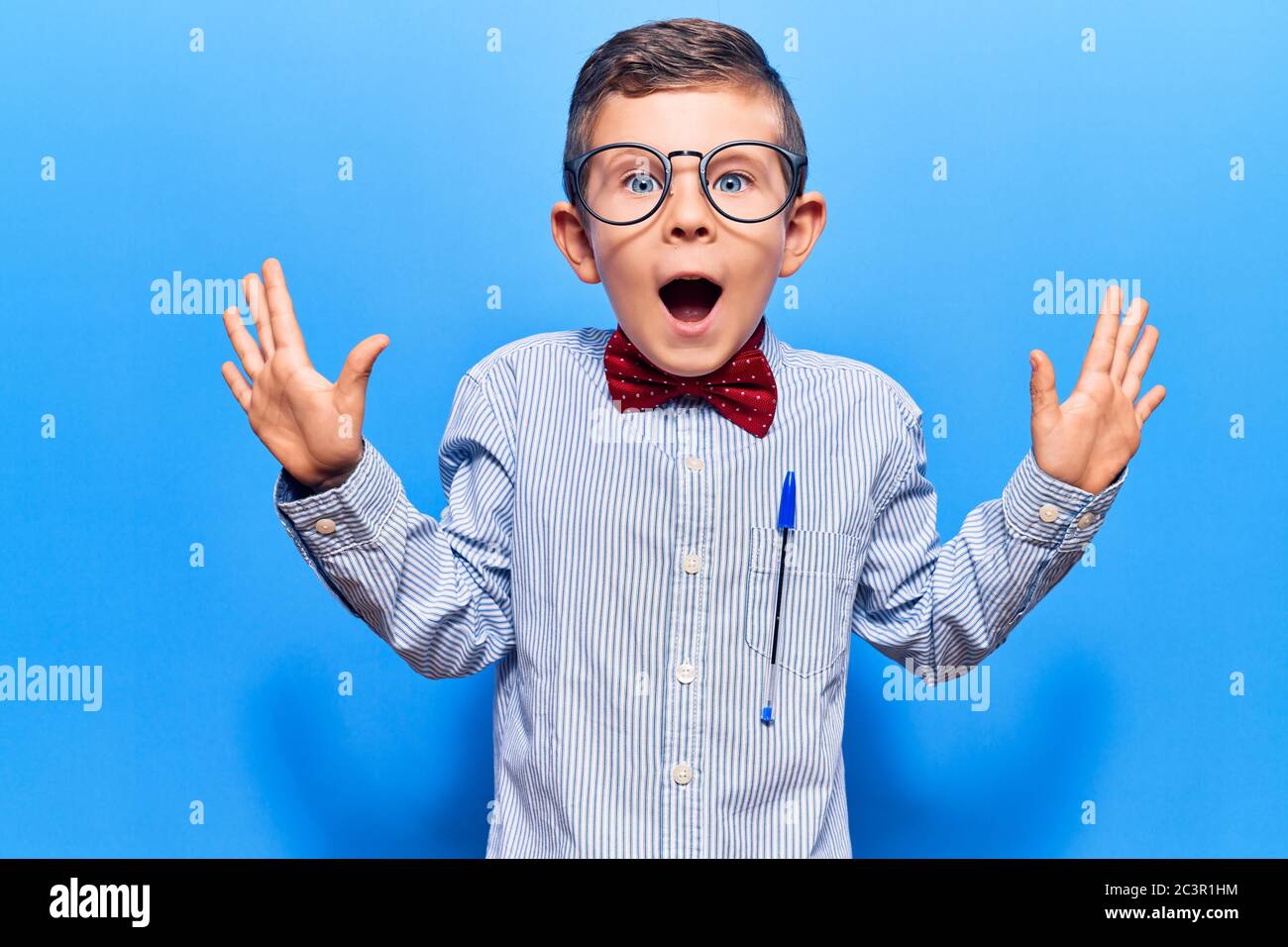Cute blond kid wearing nerd bow tie and glasses celebrating crazy and ...