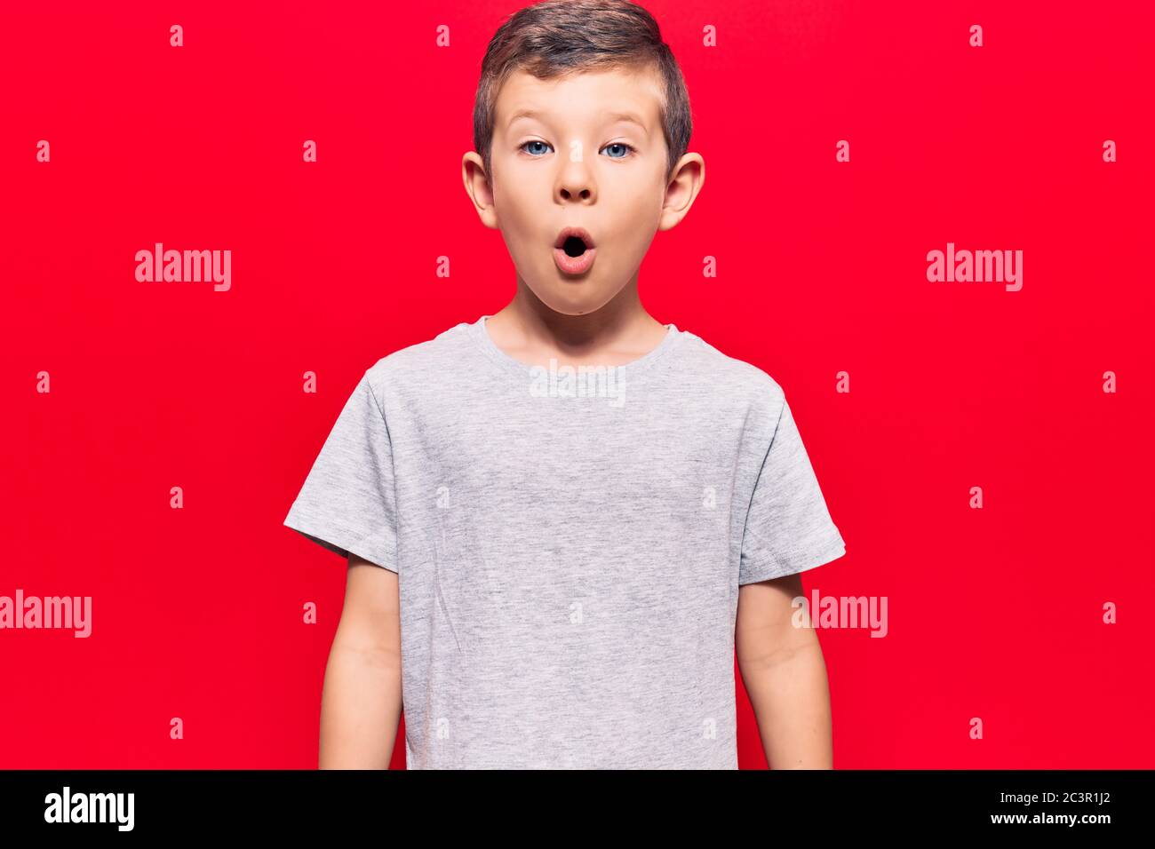 Cute blond kid wearing casual clothes scared and amazed with open mouth ...
