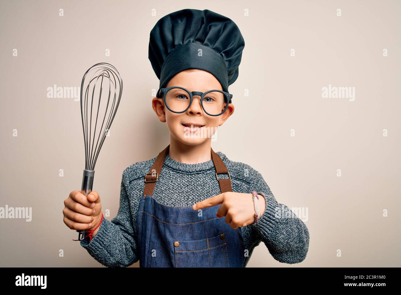 Young little caucasian cook kid wearing chef uniform and hat using ...