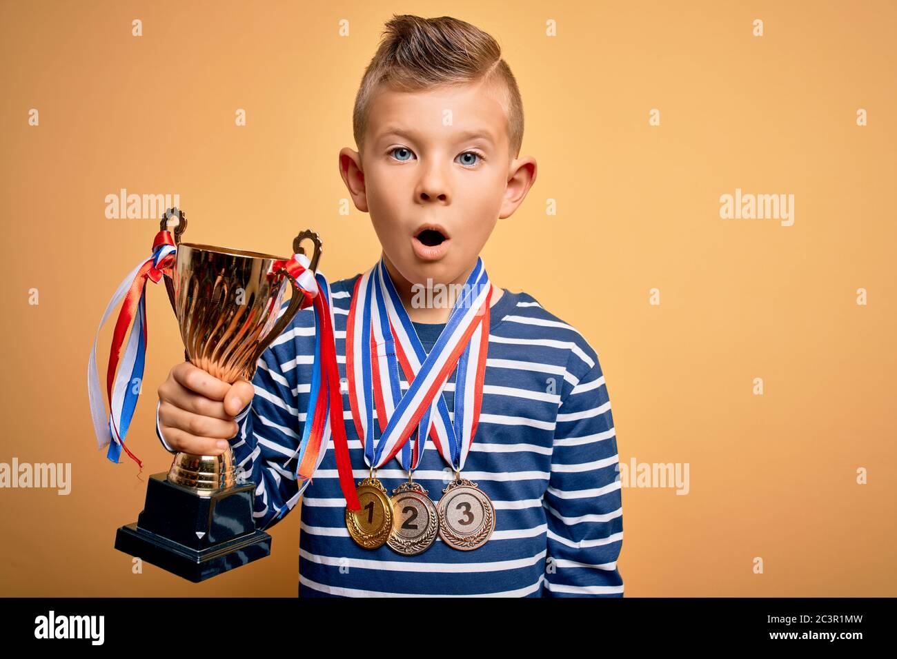 Young little caucasian kid wearing winner medals and victory award ...