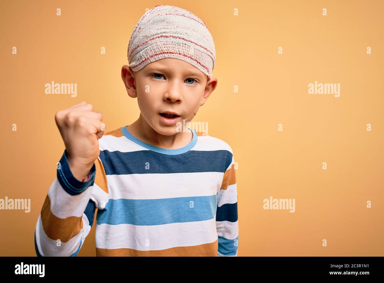 Young little caucasian kid injured wearing medical bandage on head over ...