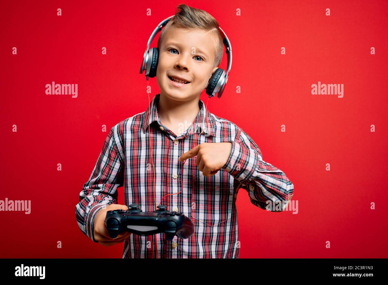 Young little caucasian gamer kid playing video games using gamepad ...
