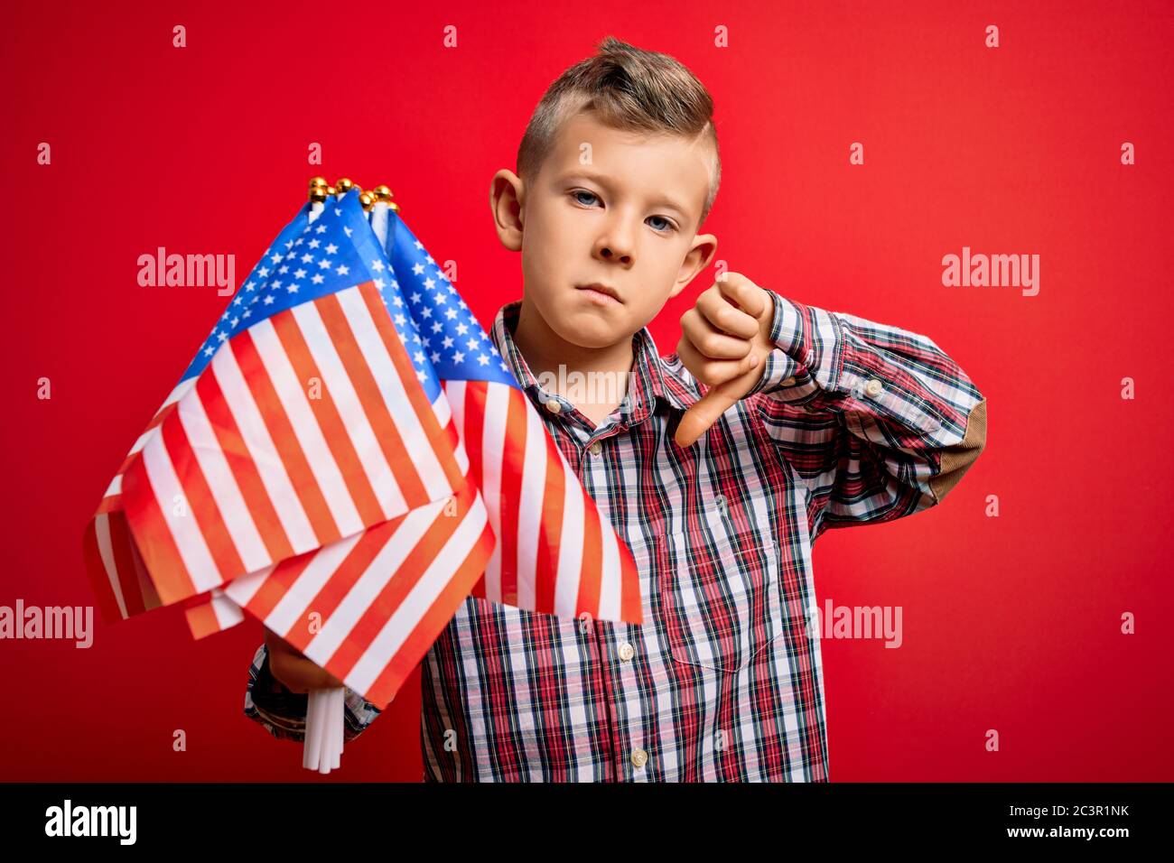 Young little american patriotic caucasian kid holding flag of USA over ...