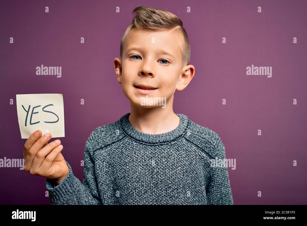 Young little caucasian kid showing YES word on a paper note as positive ...