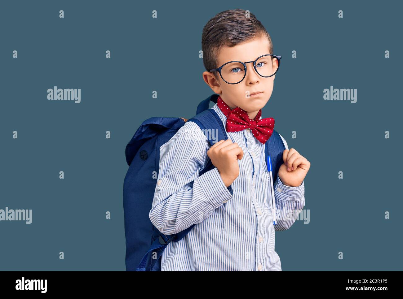 Cute blond kid wearing nerd bow tie and backpack thinking attitude and ...