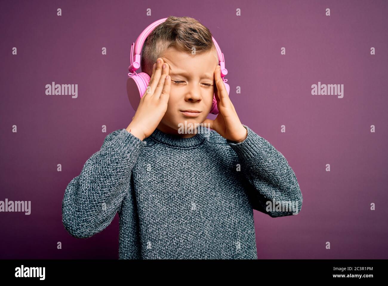 Young little caucasian kid wearing headphones listening to music over ...