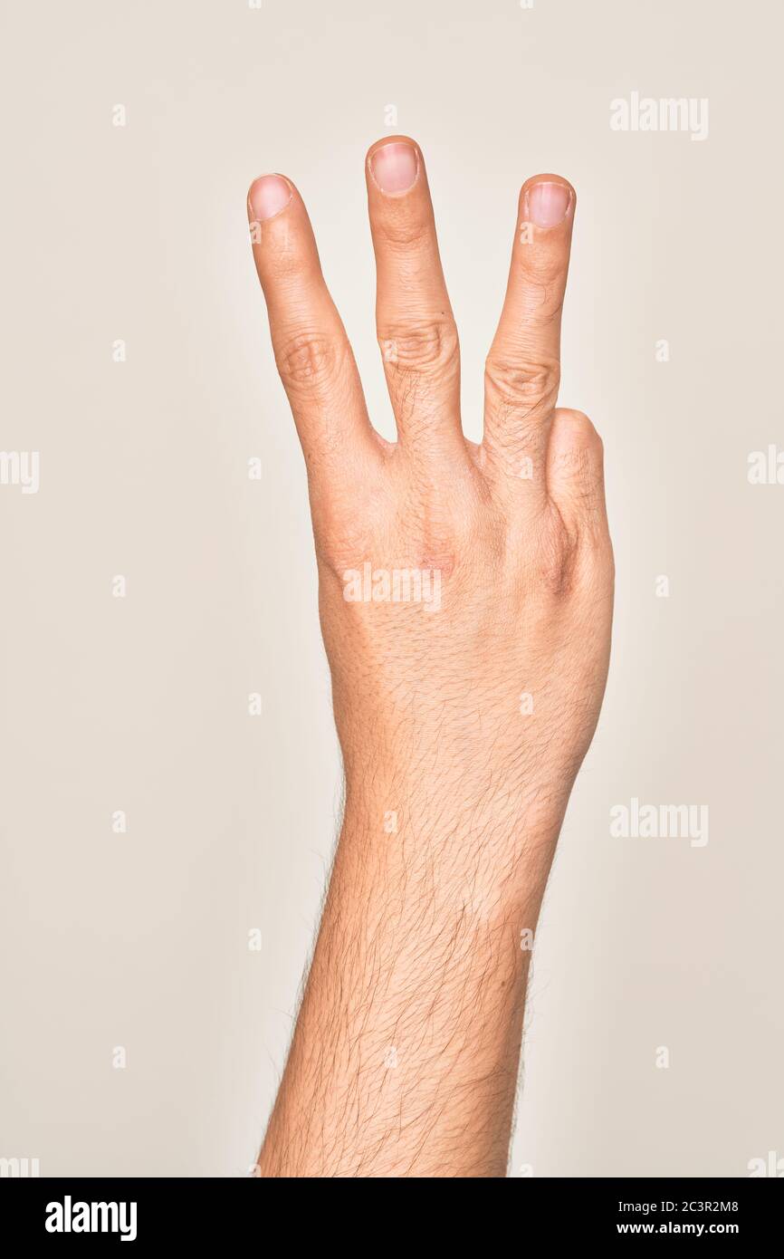 Hand of caucasian young man showing fingers over isolated white background counting number 3 ...