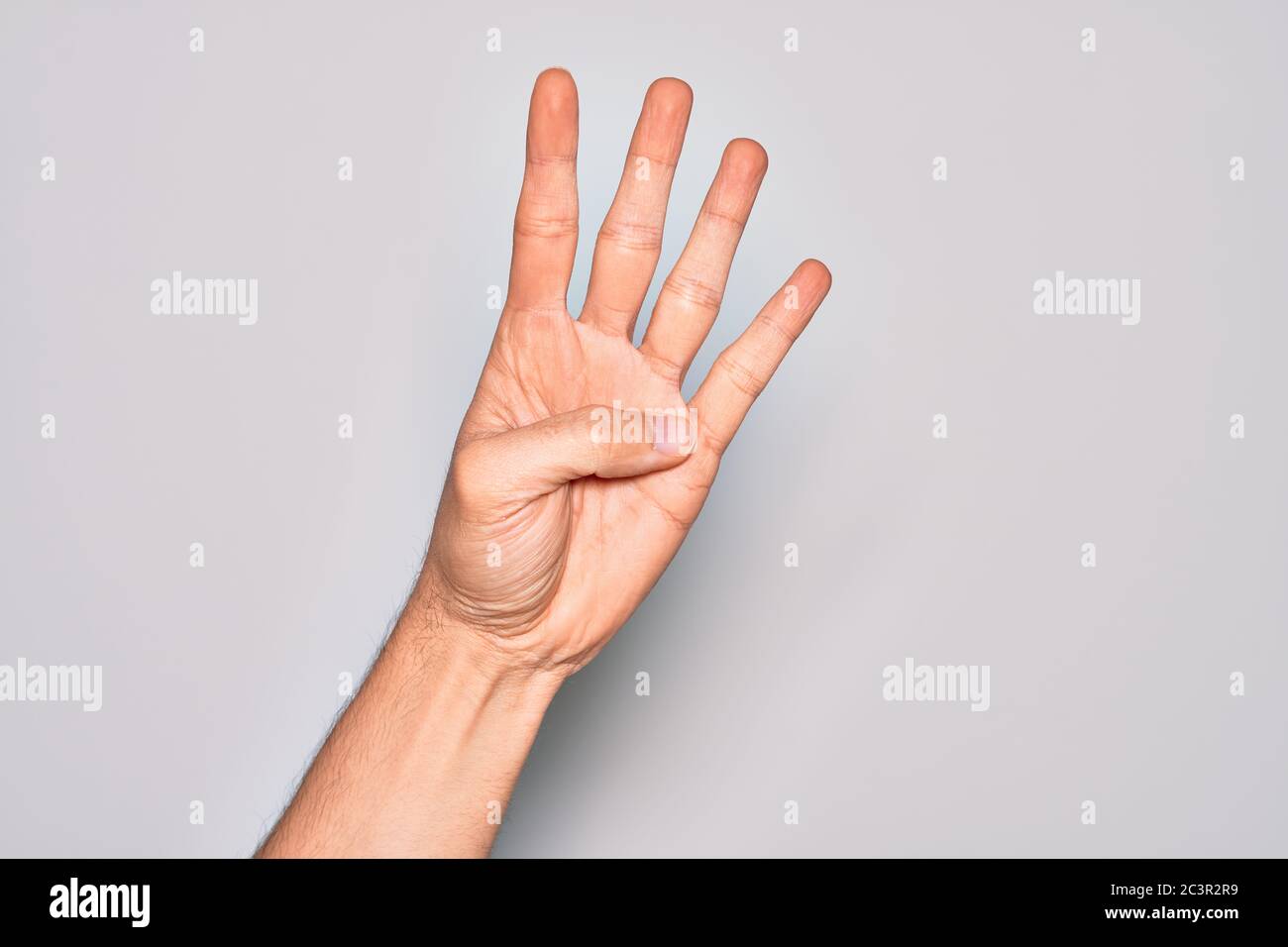 Hand of caucasian young man showing fingers over isolated white background counting number 4 ...
