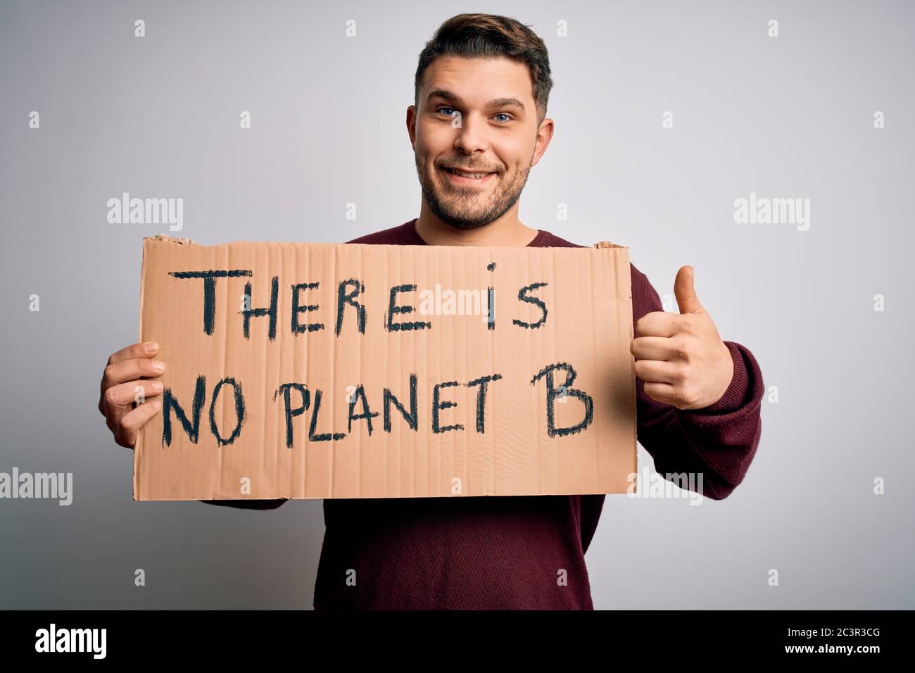 Young activist man holding protest banner for climate change and ...