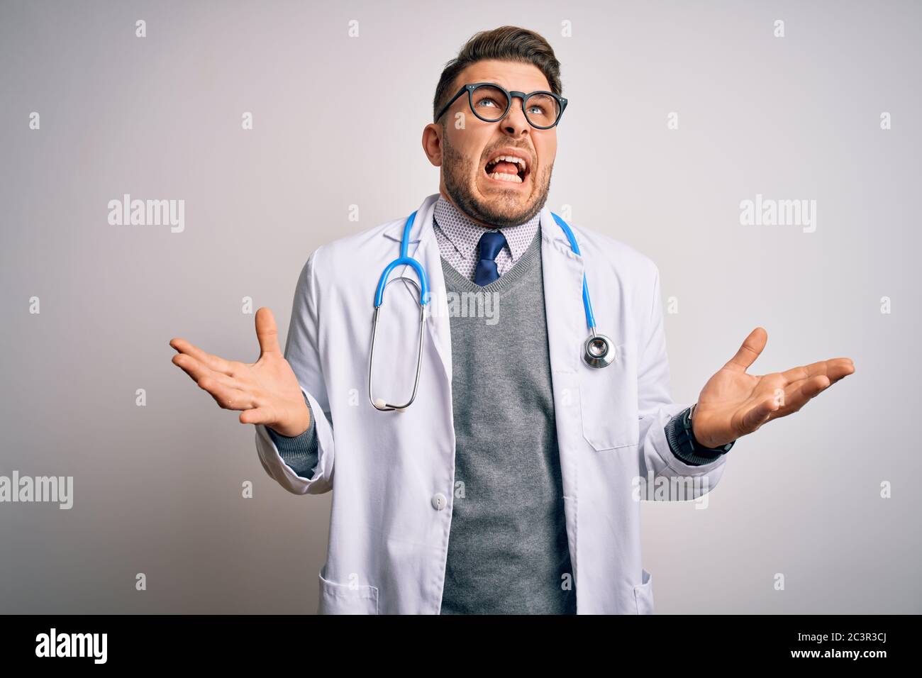 Young doctor man with blue eyes wearing medical coat and stethoscope ...