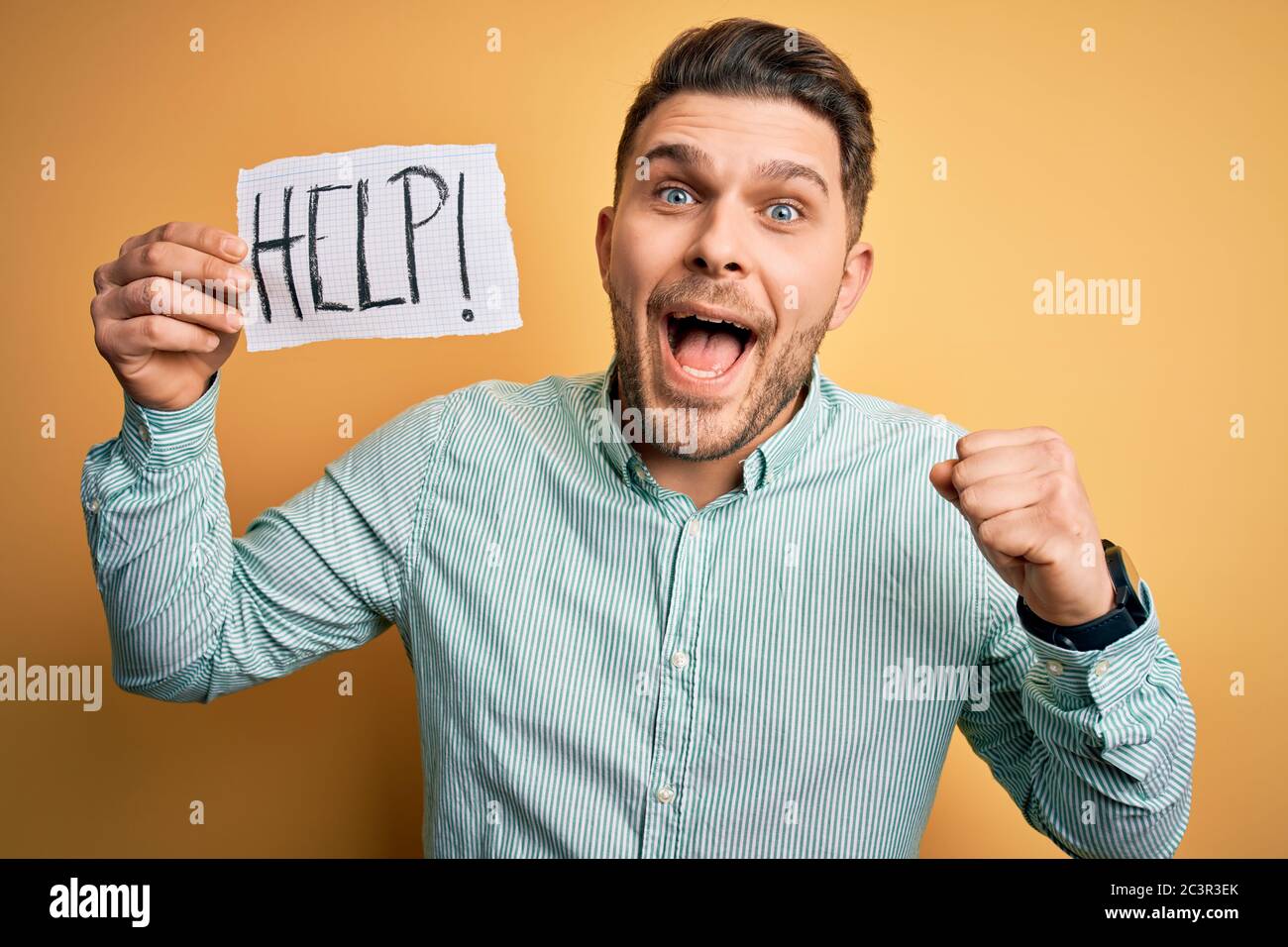 Young business man with blue eyes asking for help holding paper note ...