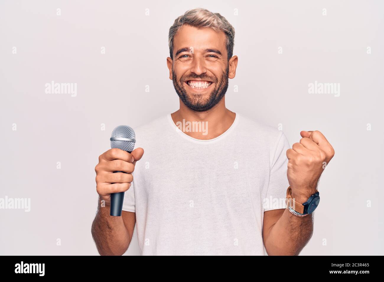 Handsome blond singer man with beard singing song using microphone over ...