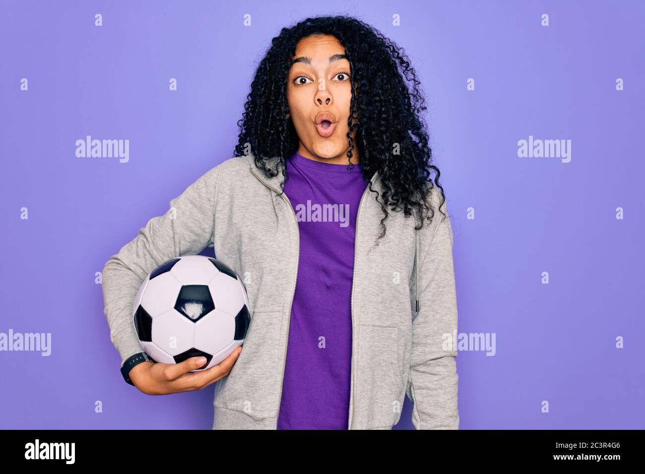 African american curly player woman playing soccer holding football bal ...