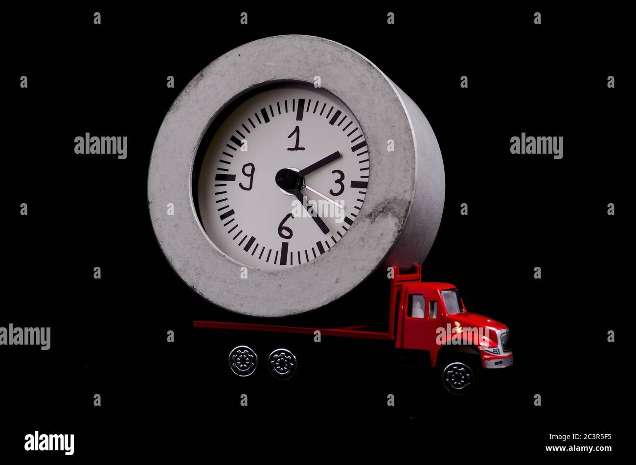 Time Transportation Concept Clock Watch on a Red Toy Truck over Black ...