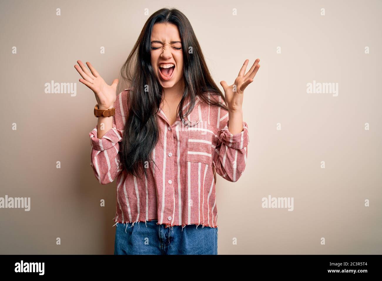 Young brunette woman wearing casual striped shirt over isolated ...