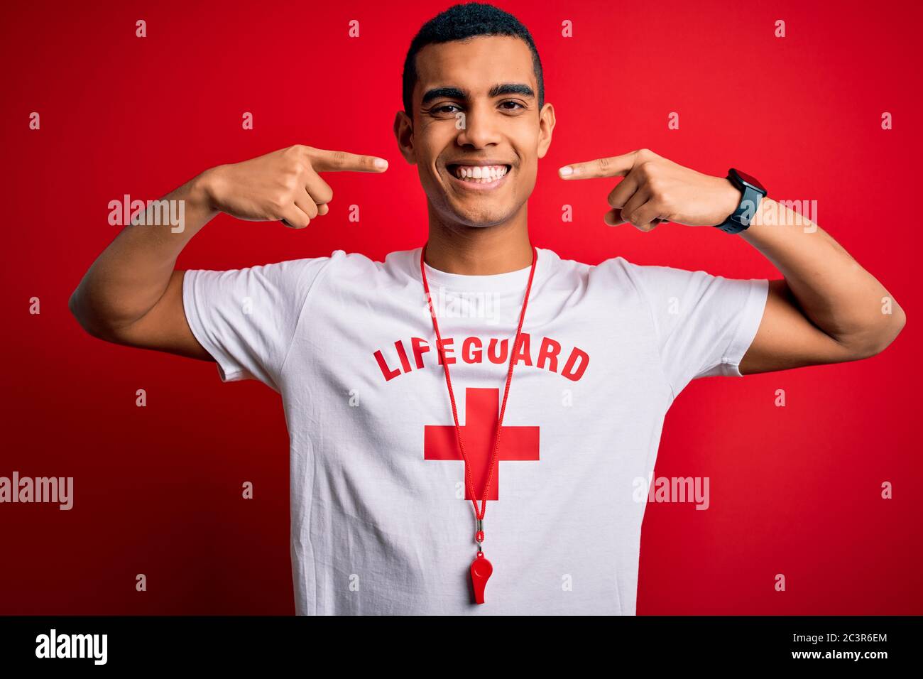 Young handsome african american lifeguard man wearing t-shirt with red ...