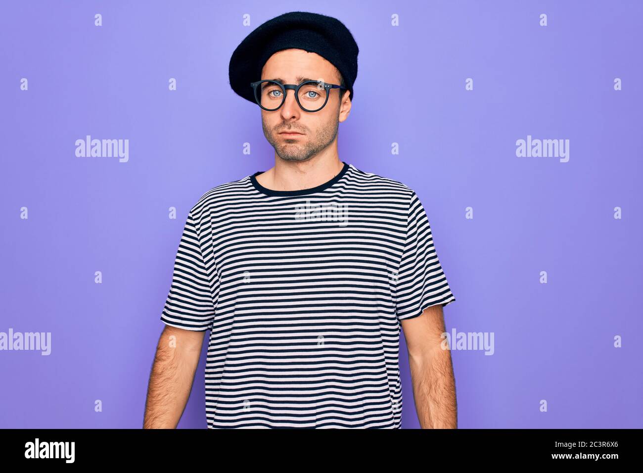 Handsome man with blue eyes wearing striped t-shirt and french beret ...