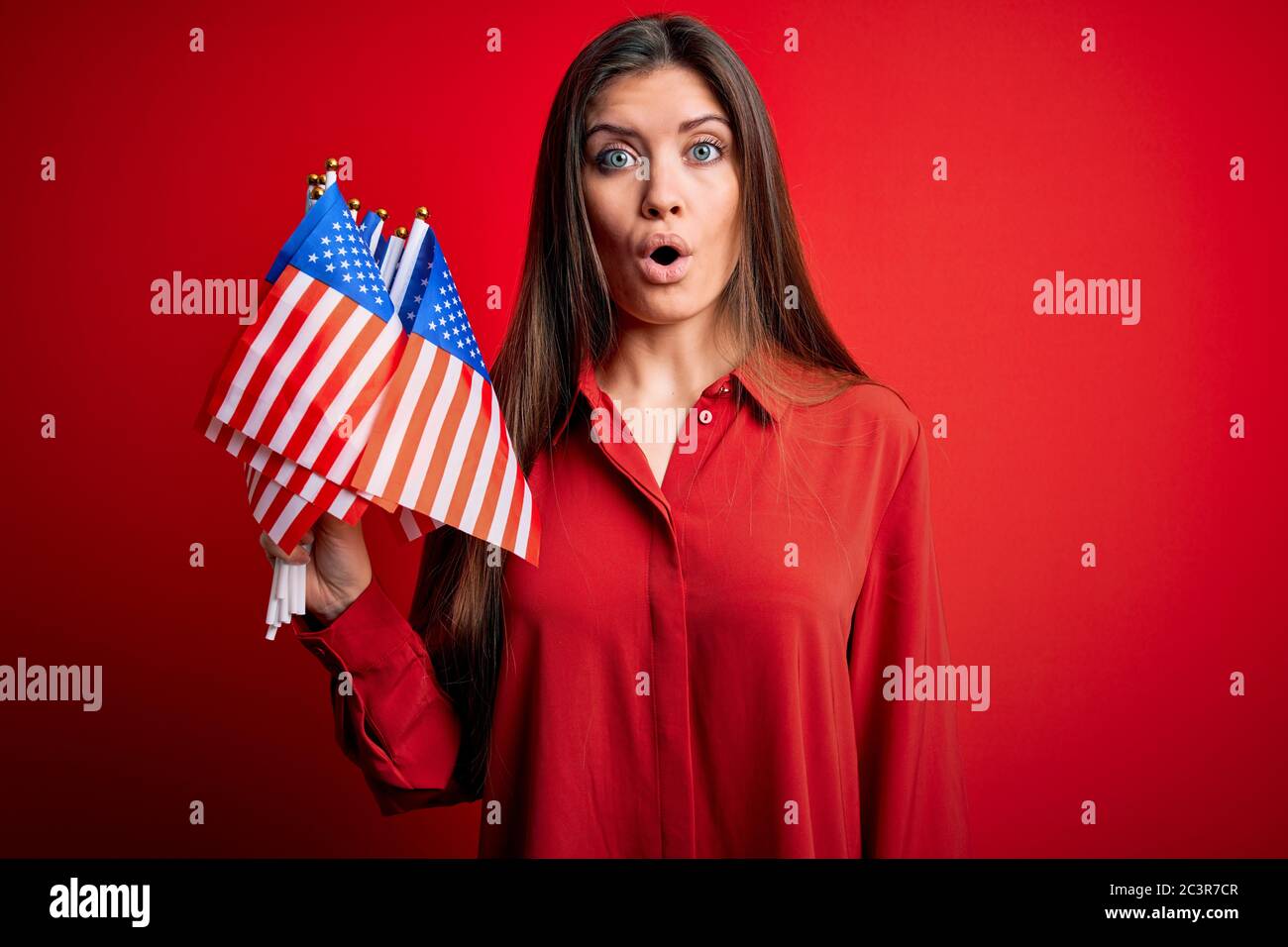 Young beautiful patriotic woman with blue eyes holding united states ...
