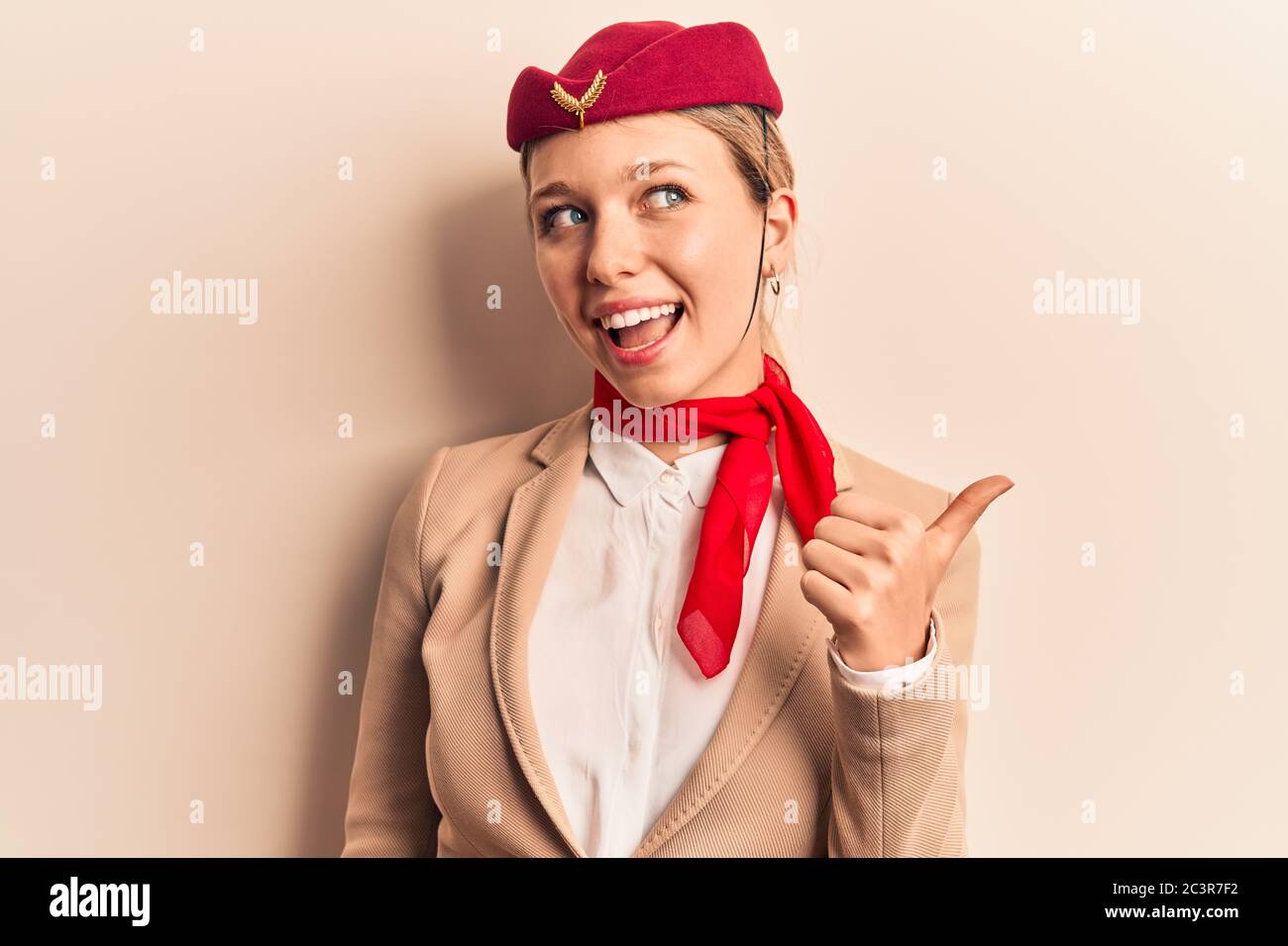Young beautiful blonde girl wearing stewardess uniform smiling with ...
