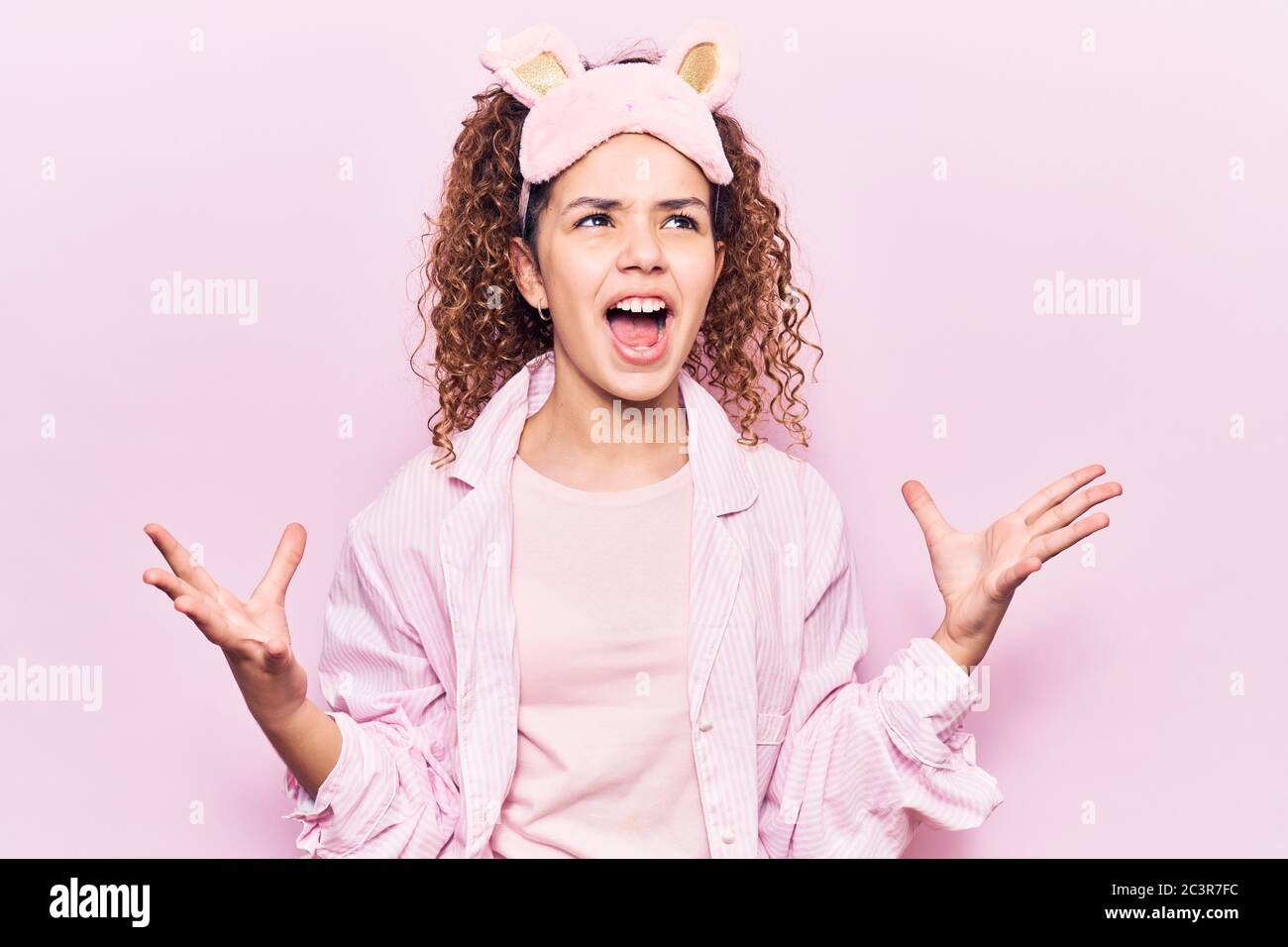 Beautiful kid girl with curly hair wearing sleep mask and pajamas crazy ...