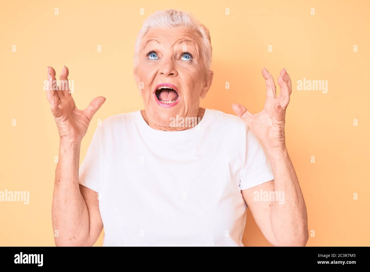 Senior beautiful woman with blue eyes and grey hair wearing classic ...
