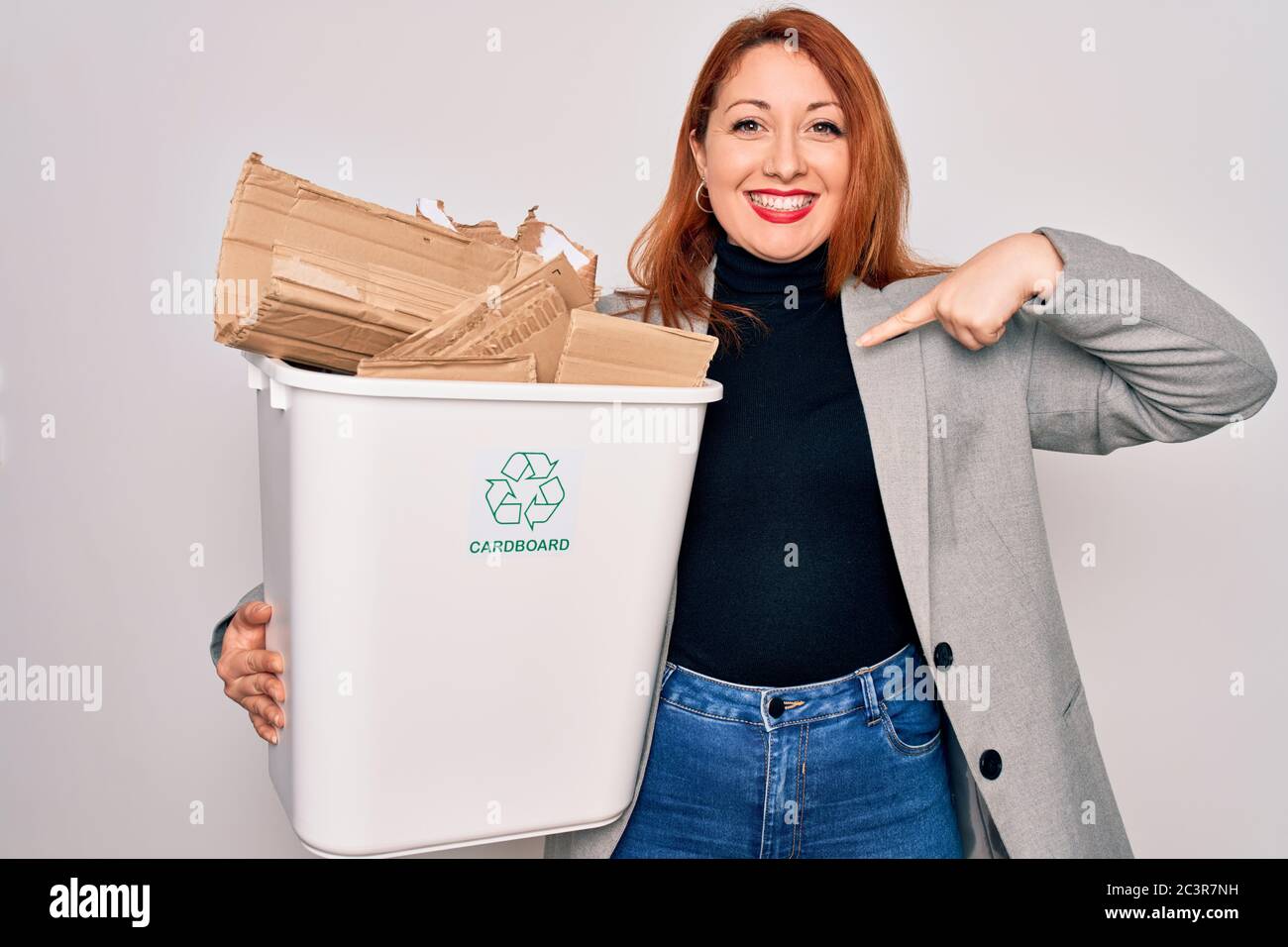 Young beautiful redhead woman recycling holding trash can with ...