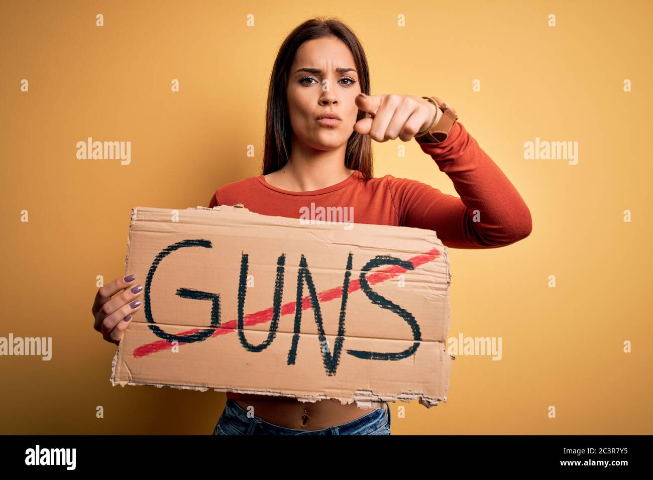 Young beautiful activist woman asking for peace holding banner with ...