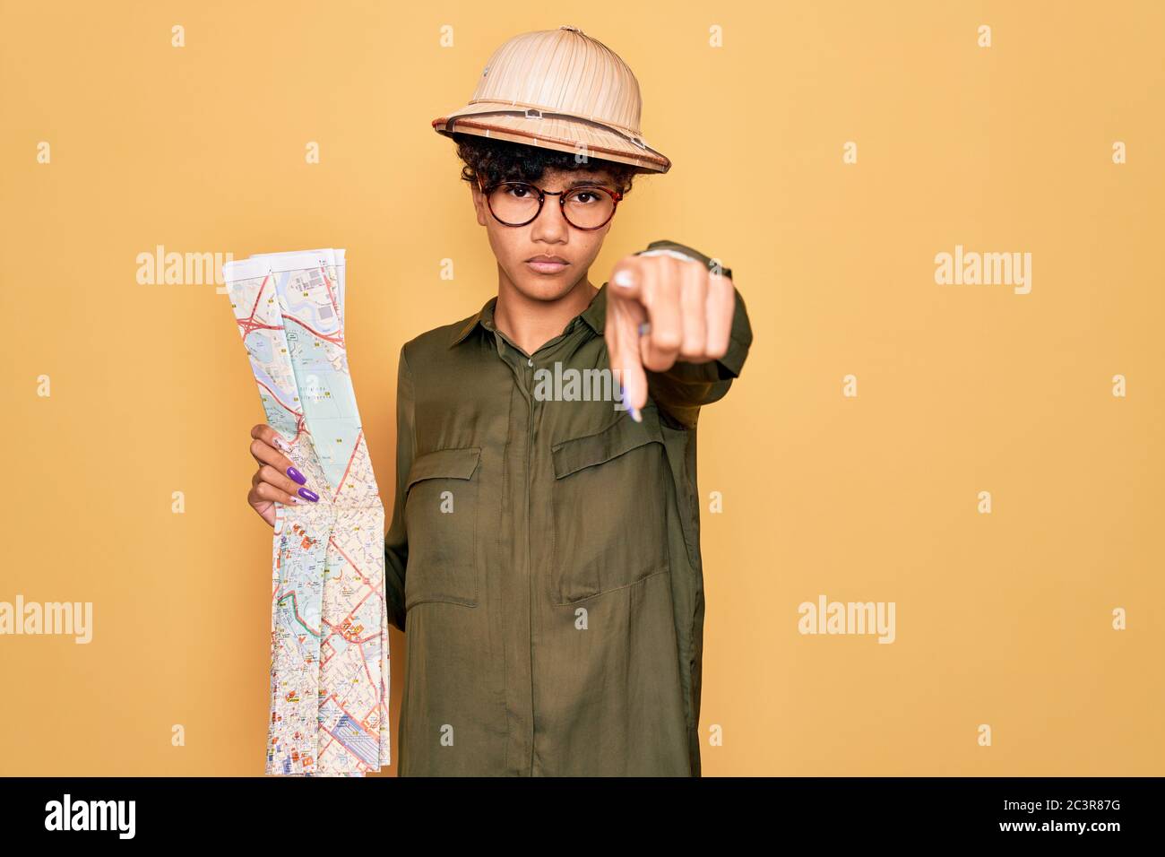 Beautiful african american explorer woman wearing hat holding city map ...