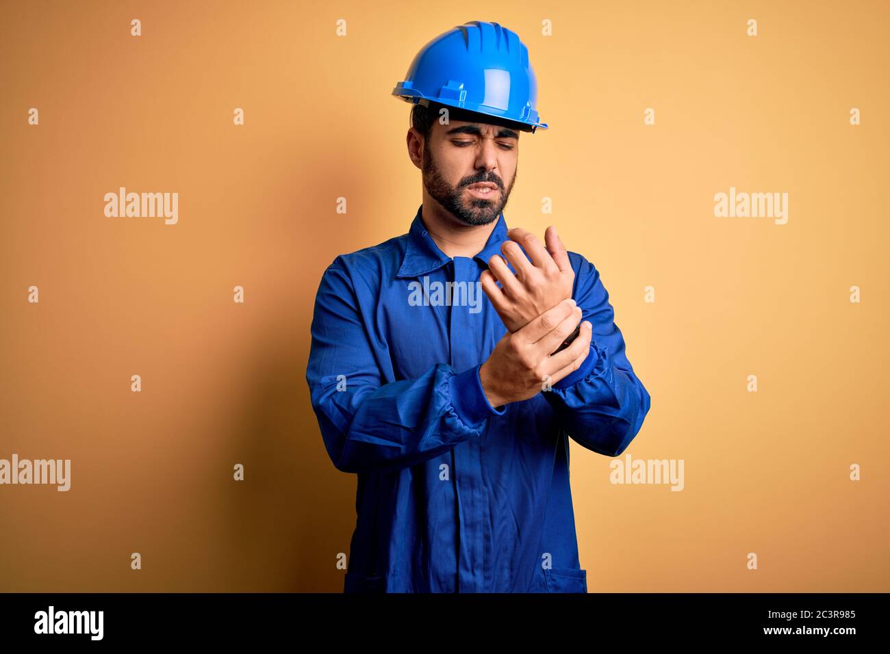 Mechanic man with beard wearing blue uniform and safety helmet over ...