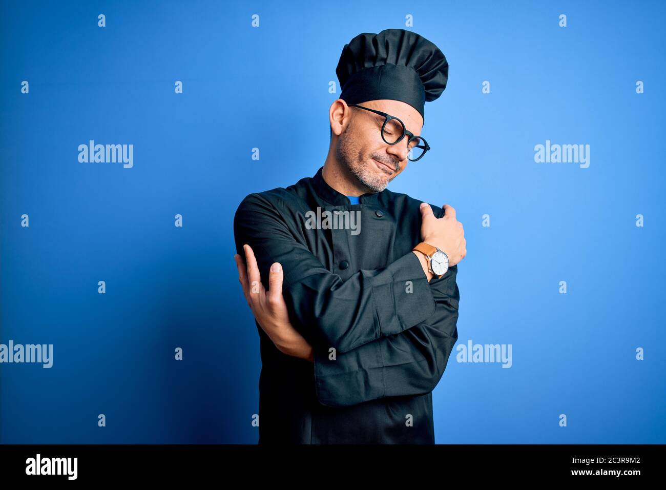 Young handsome chef man wearing cooker uniform and hat over isolated ...