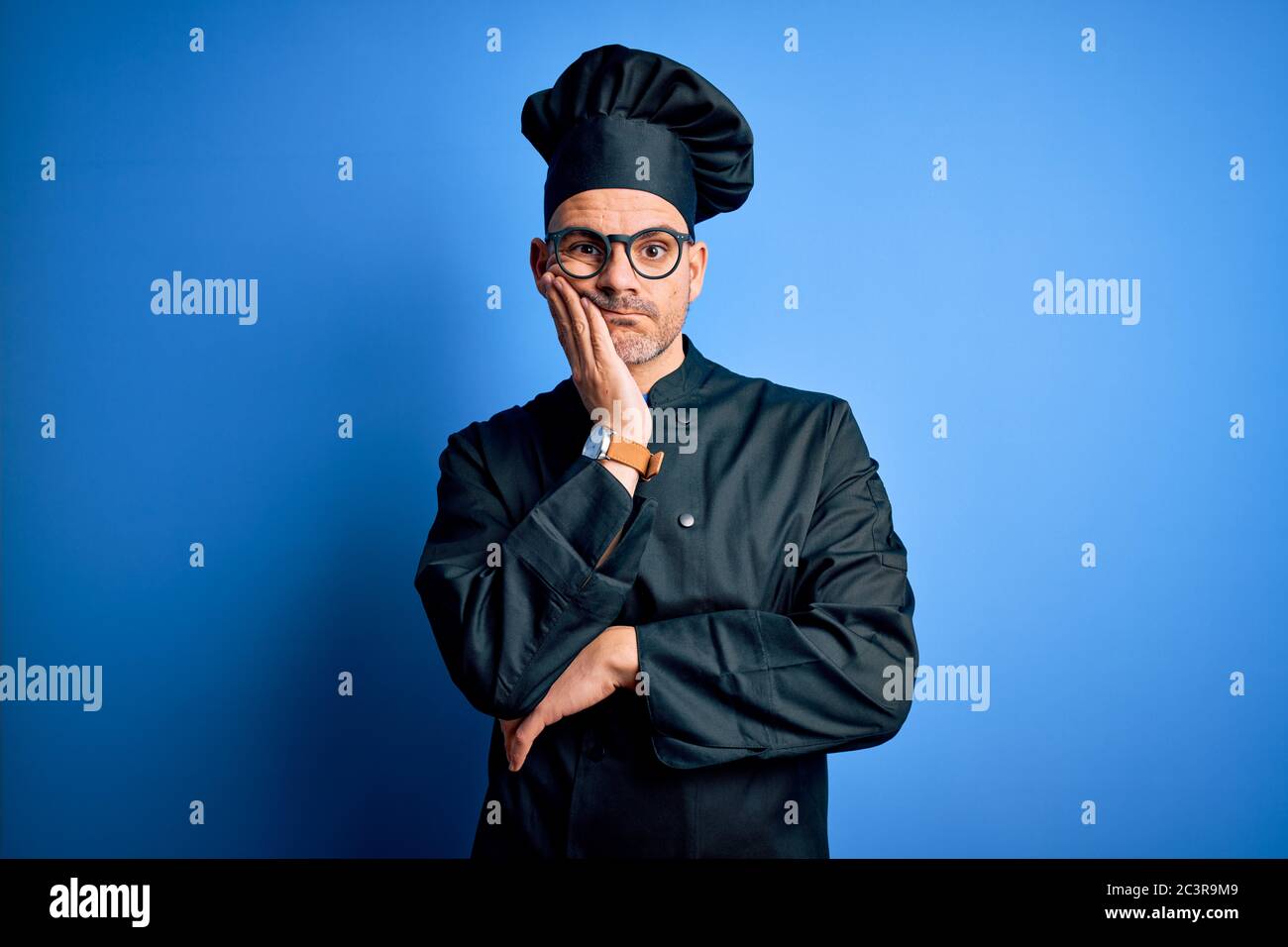 Young handsome chef man wearing cooker uniform and hat over isolated ...